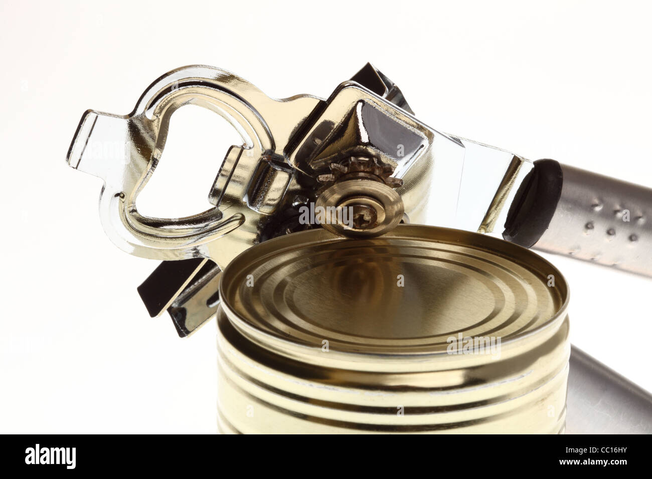 Tin opener opening a can of food isolated on white Stock Photo - Alamy