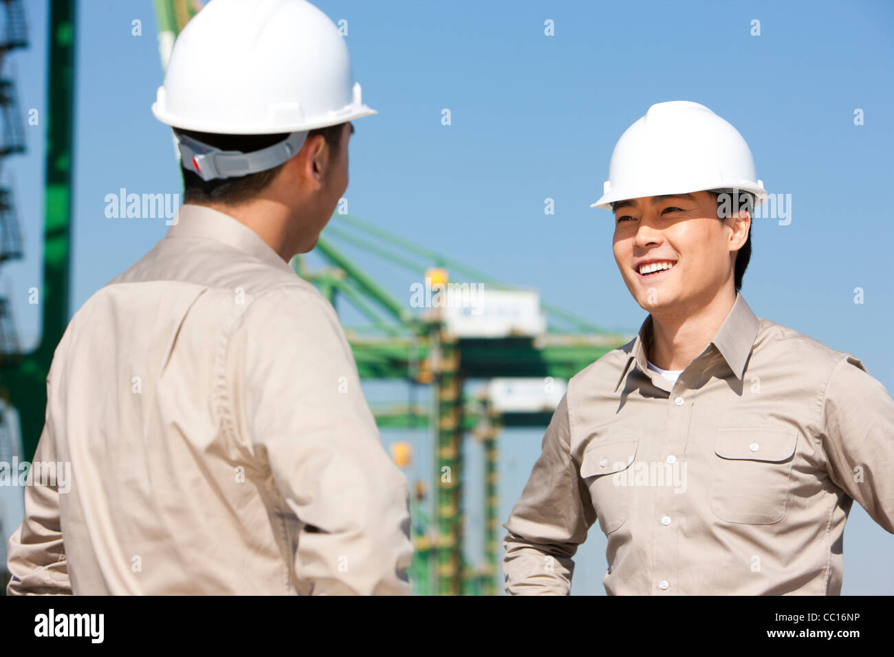 Male shipping industry workers talking Stock Photo - Alamy