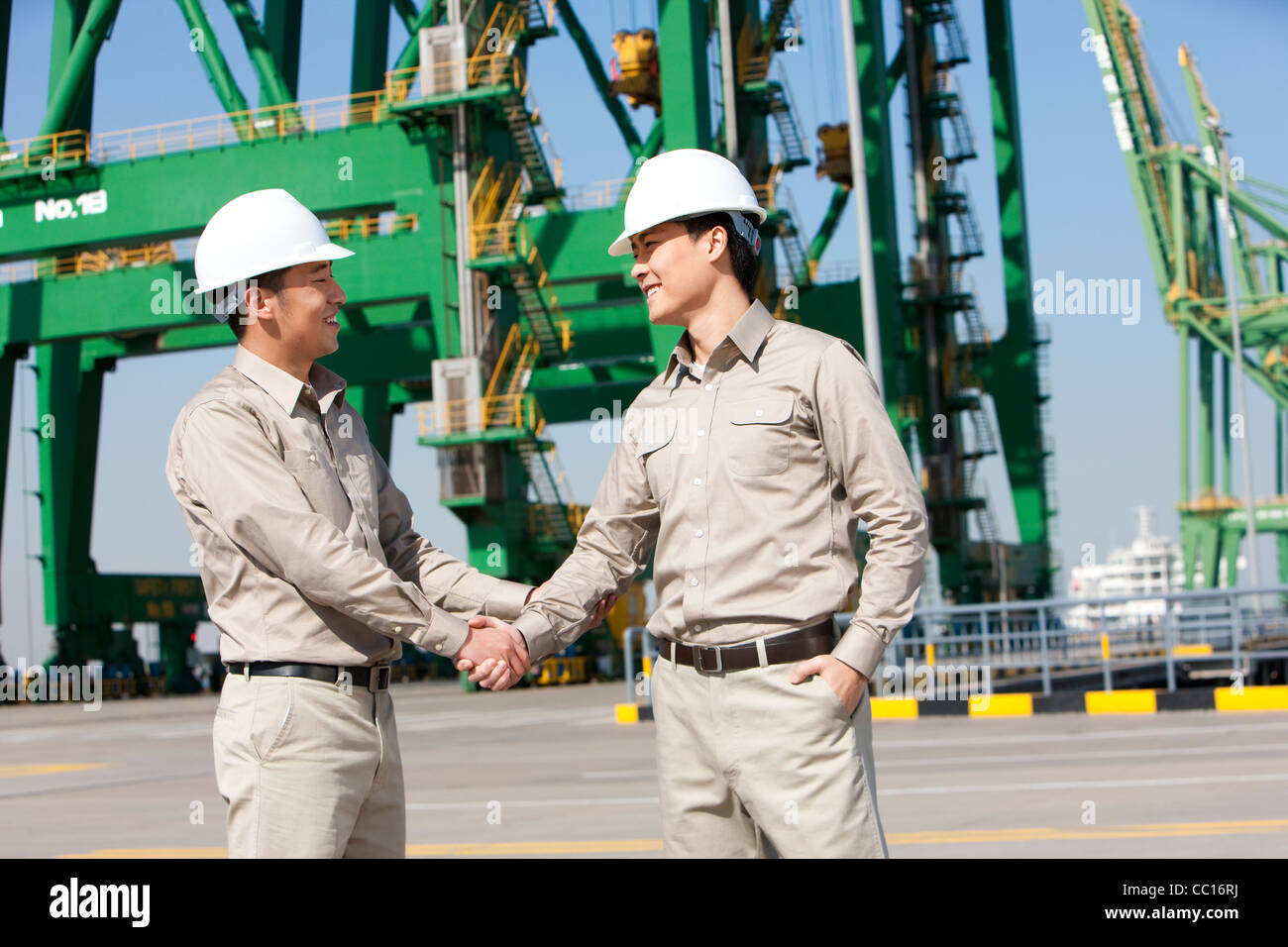 Male shipping industry workers shaking hands Stock Photo - Alamy