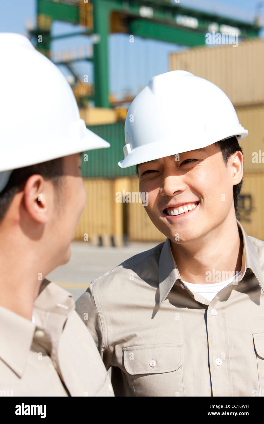 Male shipping industry workers working together Stock Photo - Alamy