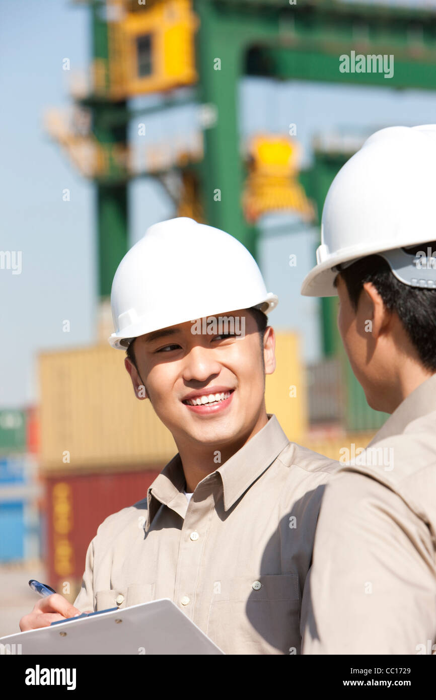 Male shipping industry workers working together Stock Photo - Alamy