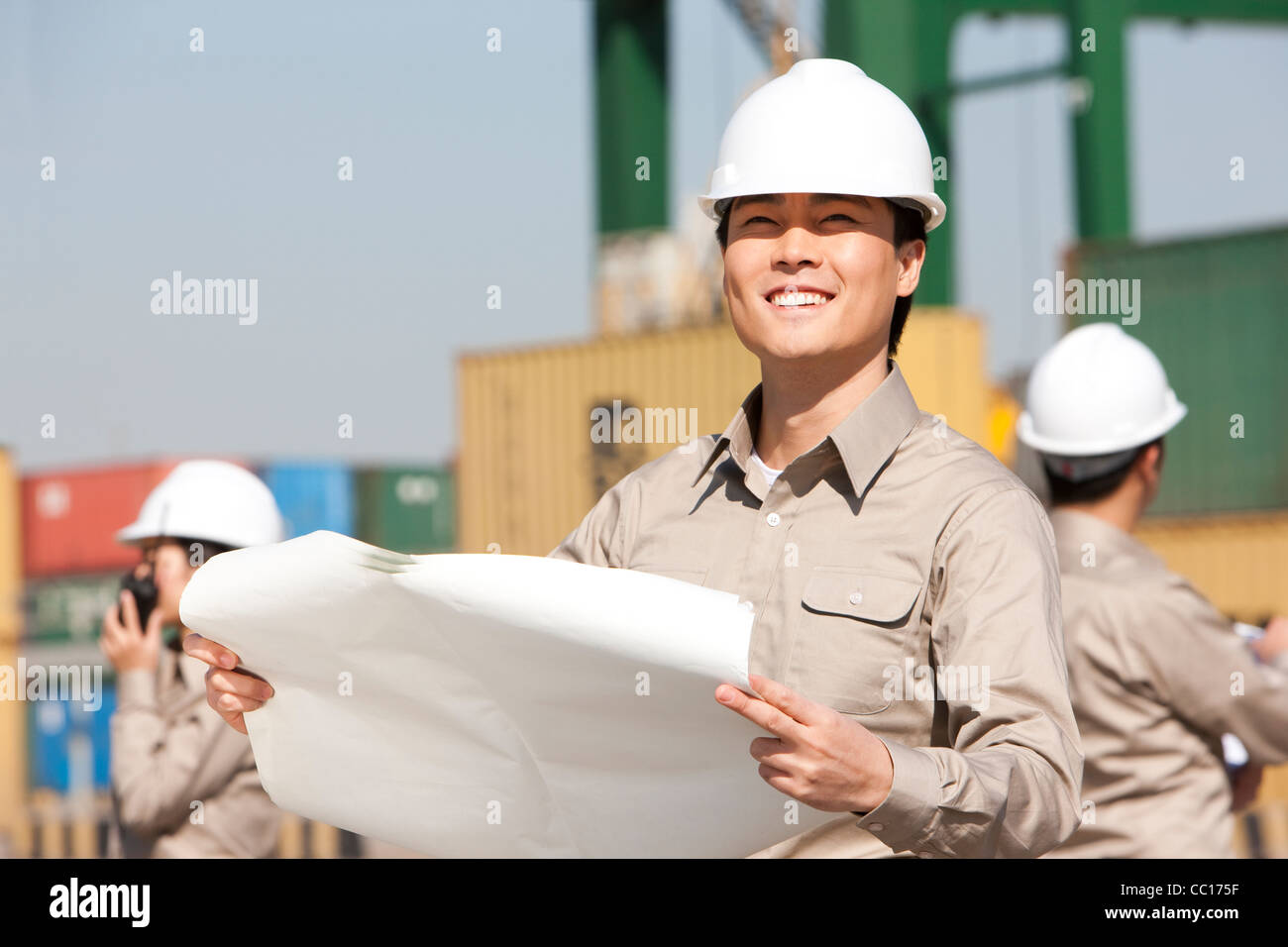 Male shipping worker checking blueprints Stock Photo - Alamy