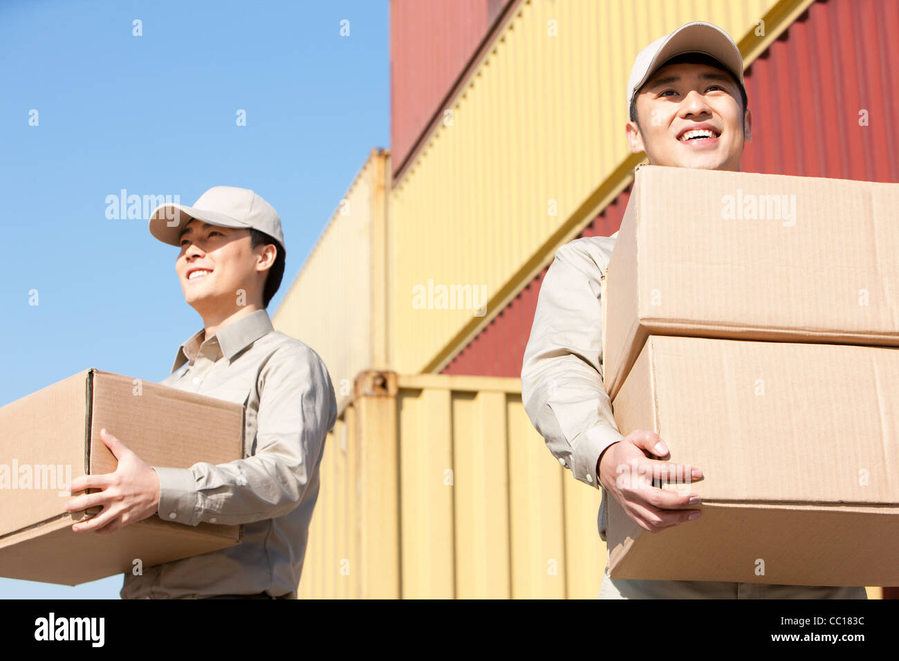 shipping industry workers carrying cardboard boxes Stock Photo - Alamy