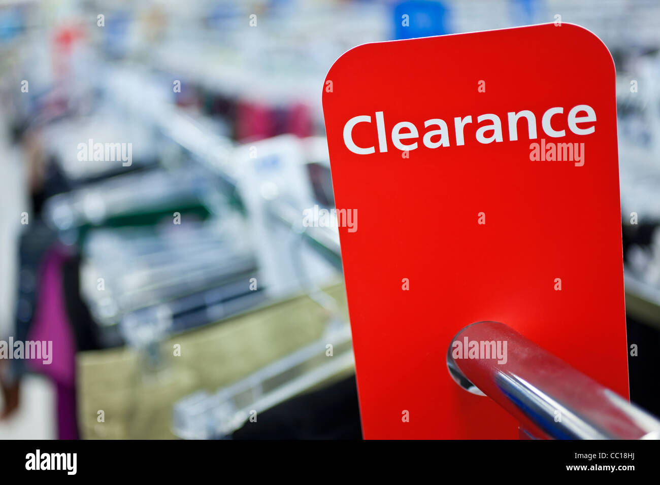 A red sale clearance sign on rail of clothes in a shop Stock Photo - Alamy