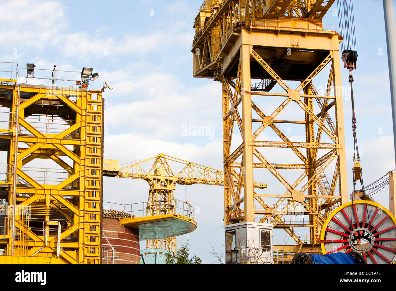 A crane lifting offshore cabling onto a ship at Duco Ltd, an offshore ...