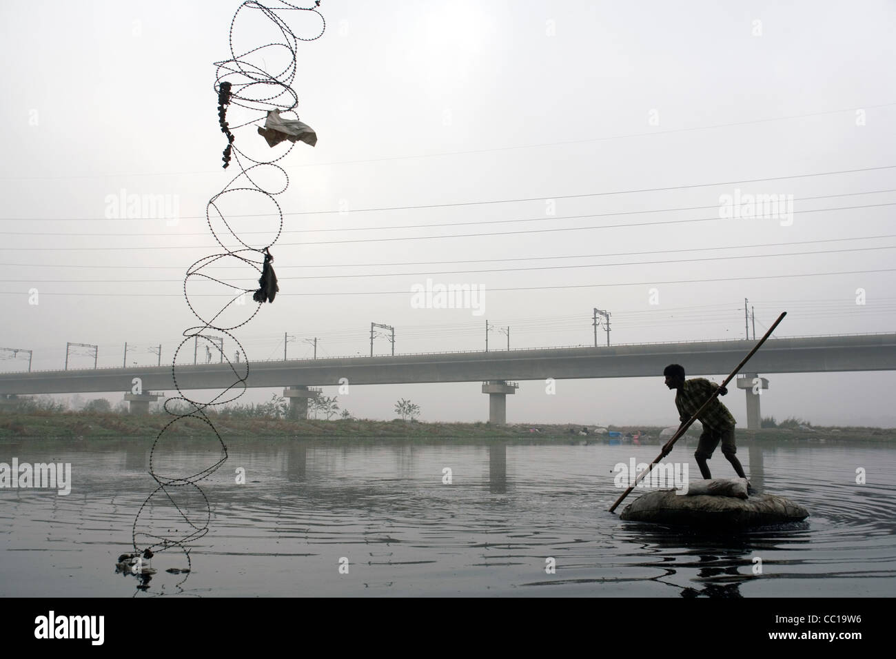A child scavenger punts his raft made of rags and plastic across the ...