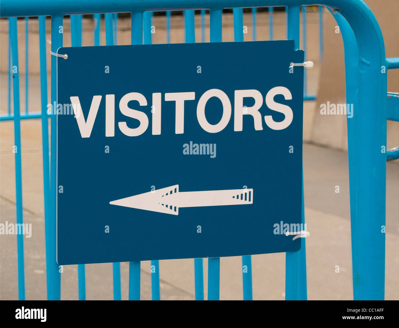 visitors sign with arrow on metal gate Stock Photo - Alamy
