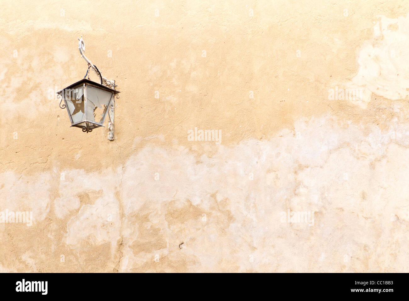 Broken lantern hanging on a cream-coloured wall Stock Photo - Alamy