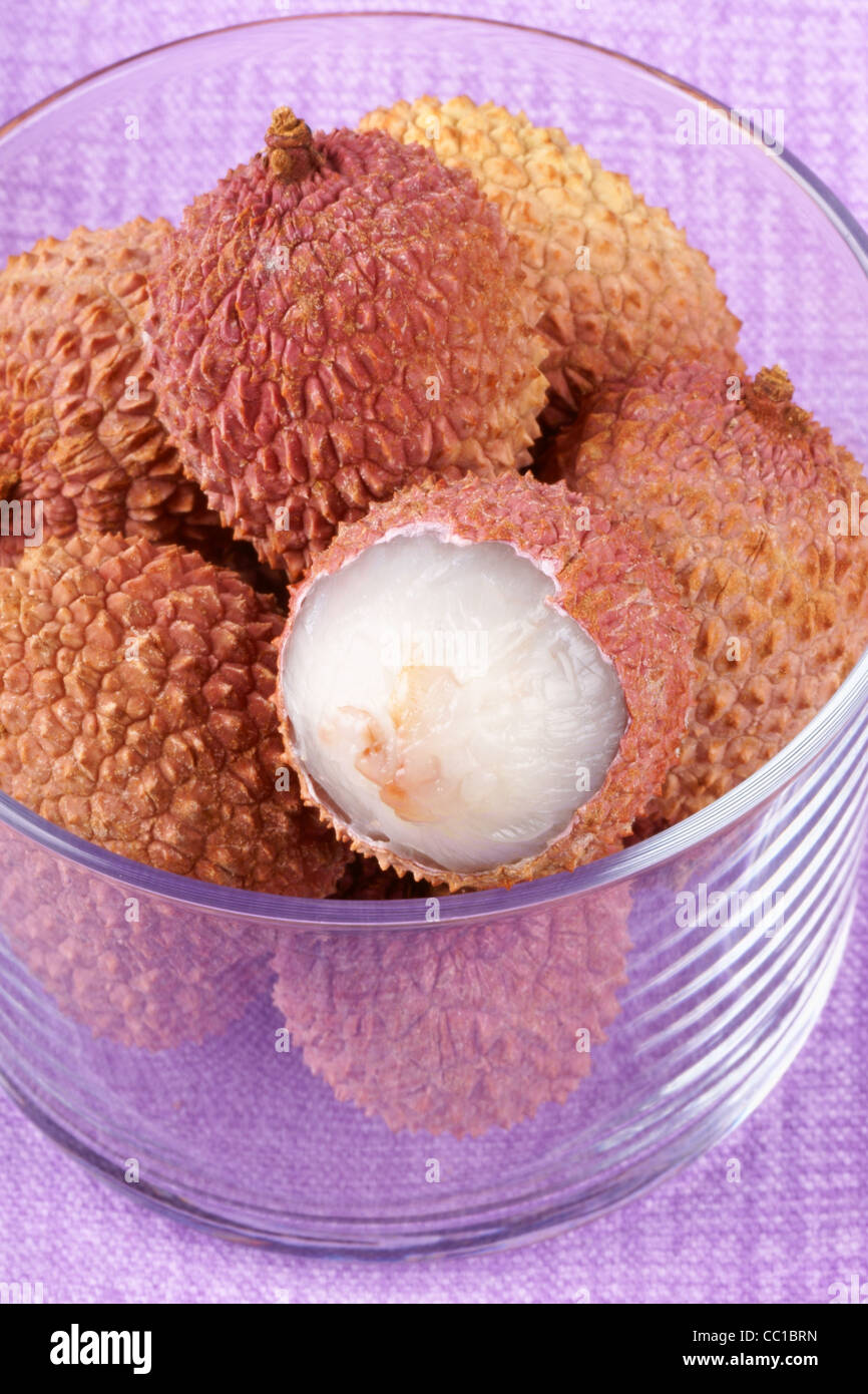 Close-up of some litchis (lychee) in a transparent glass bowl, over a ...