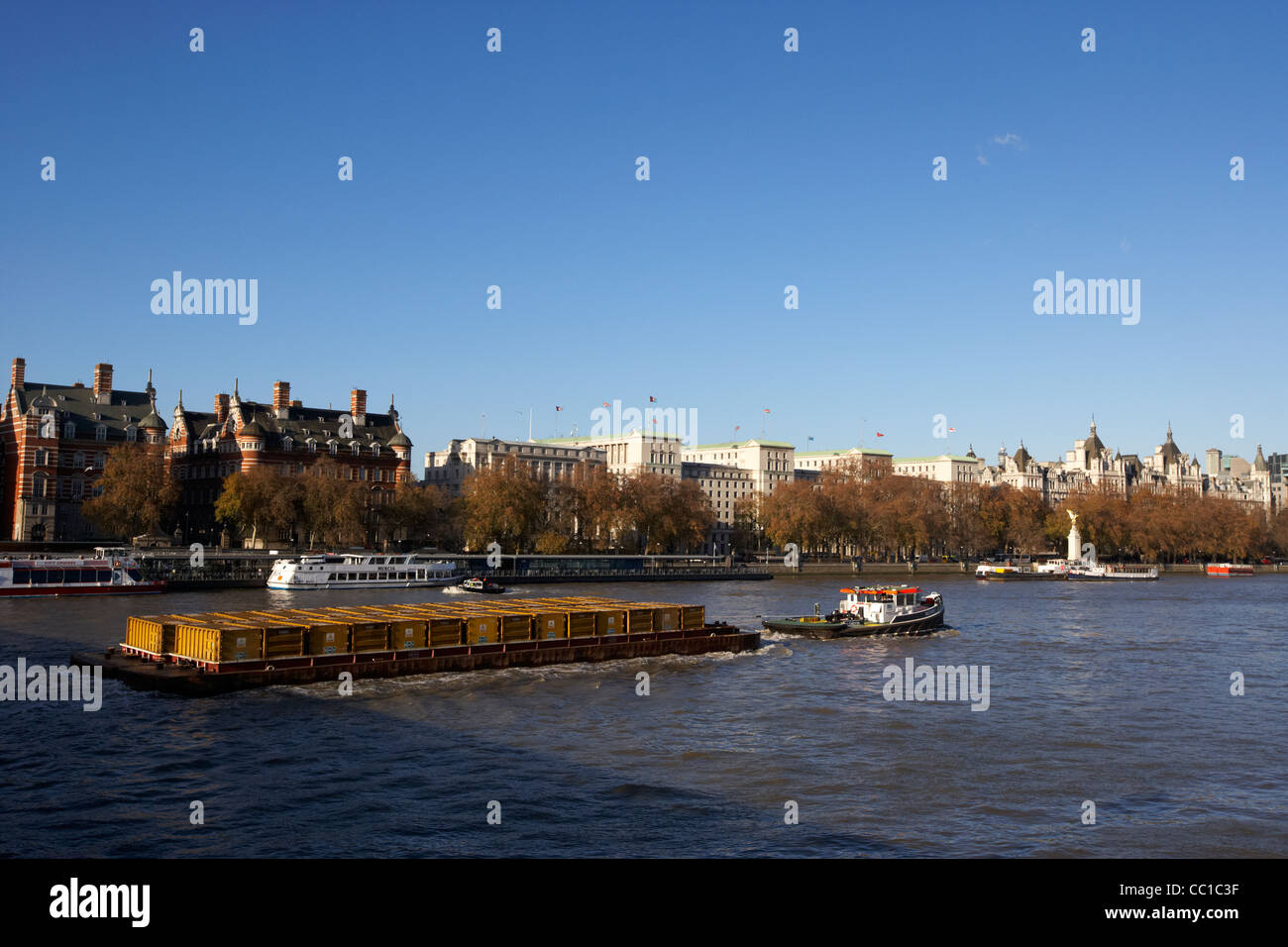 tug towing cory waste in sealed containers on barge in the river thames ...