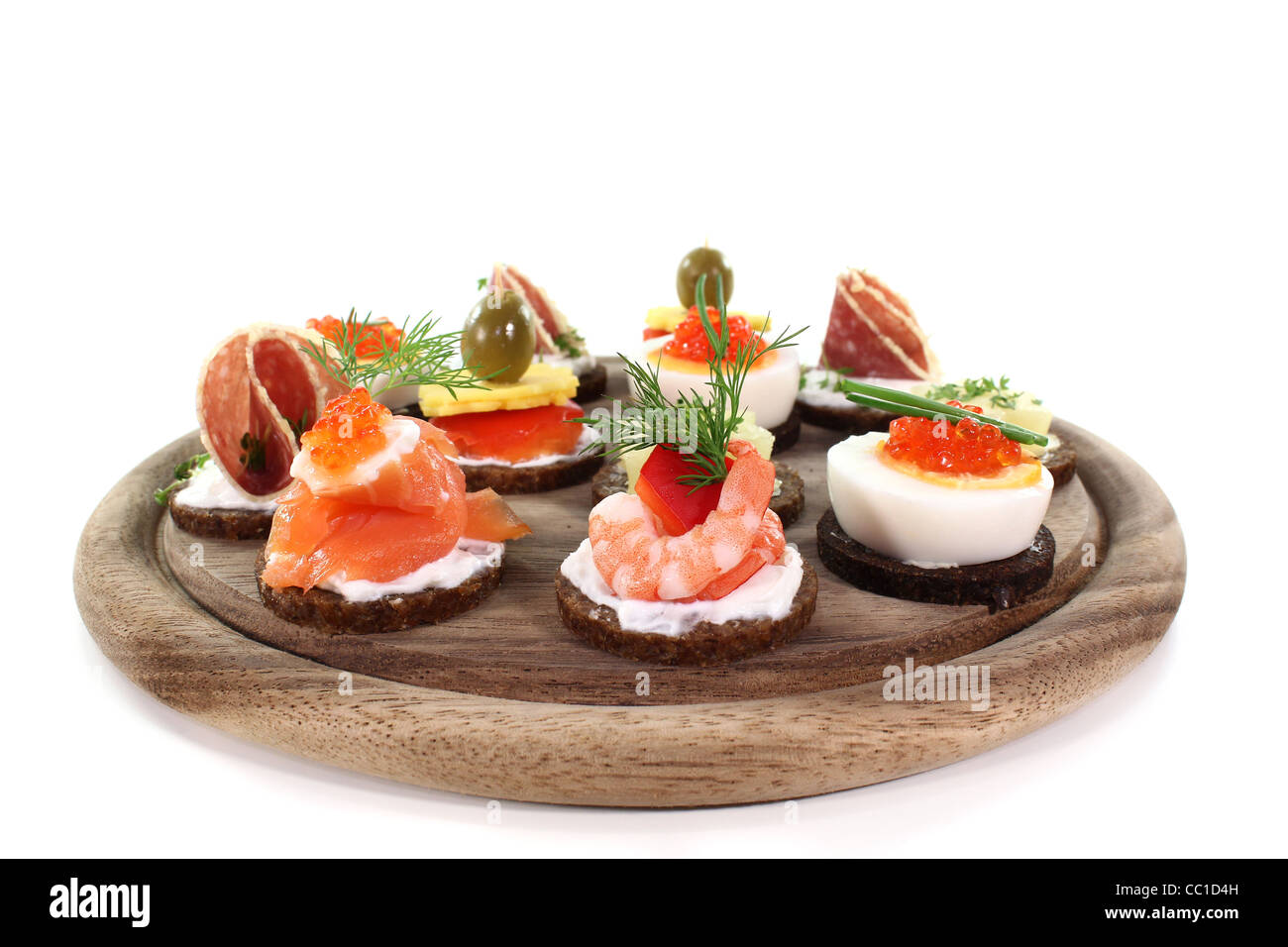 different canapés on a wooden board on a white background Stock Photo ...