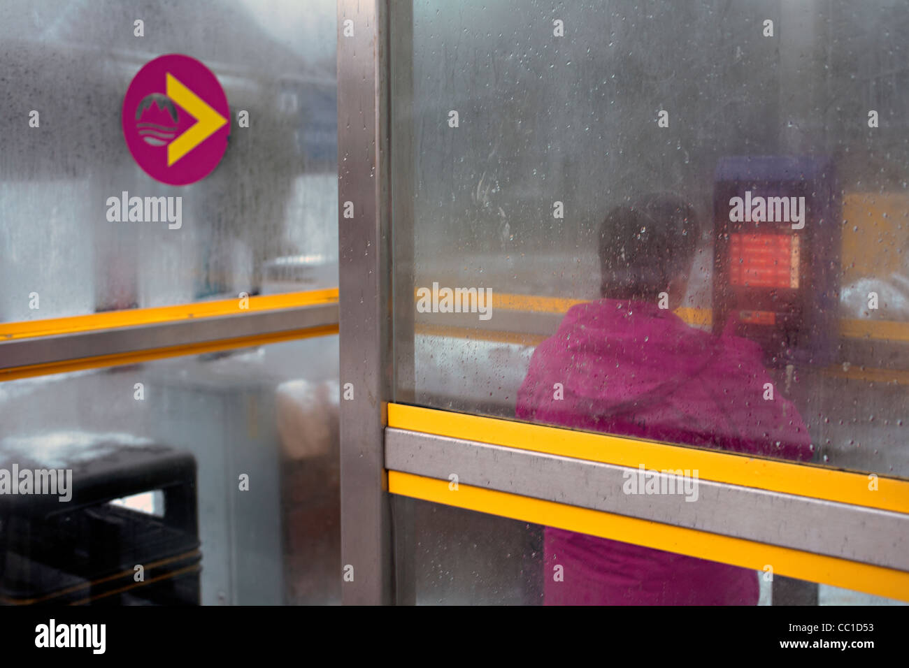 woman buying ticket in bus shelter in scotland Stock Photo - Alamy