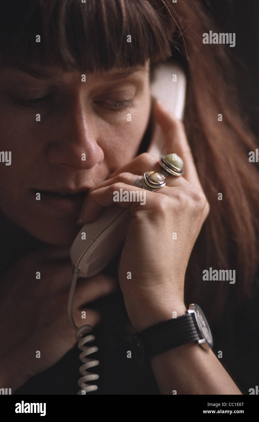 woman speaking on phone looking down cast eyes Stock Photo - Alamy