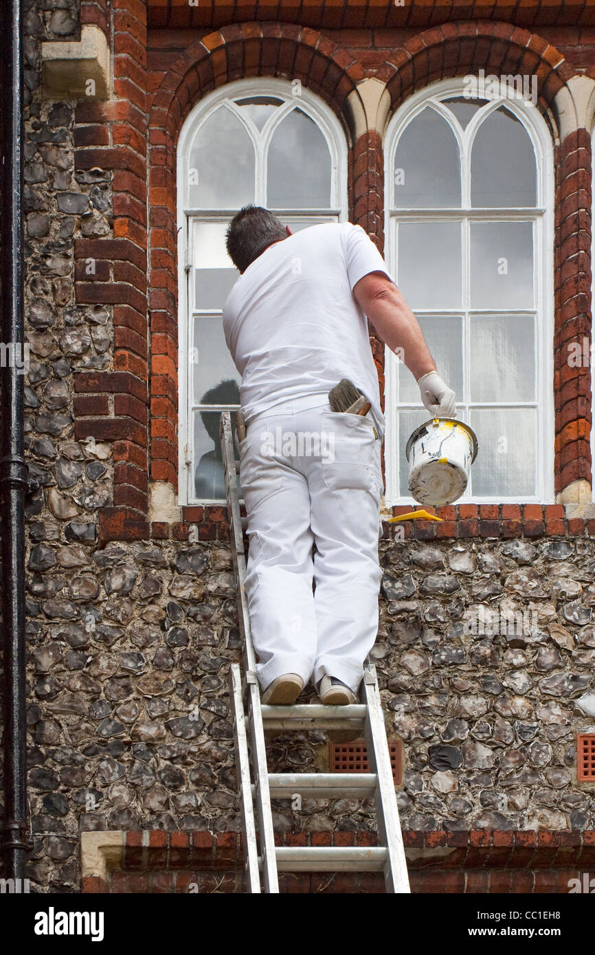 Painter and decorator working on ladder Stock Photo - Alamy