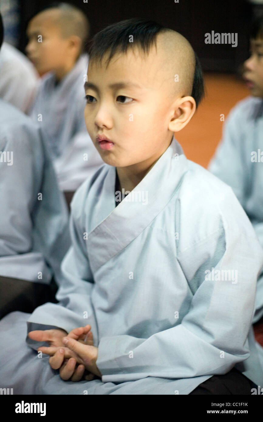 A young Buddhist monk chants sutras at the monastary at the Thienmu ...