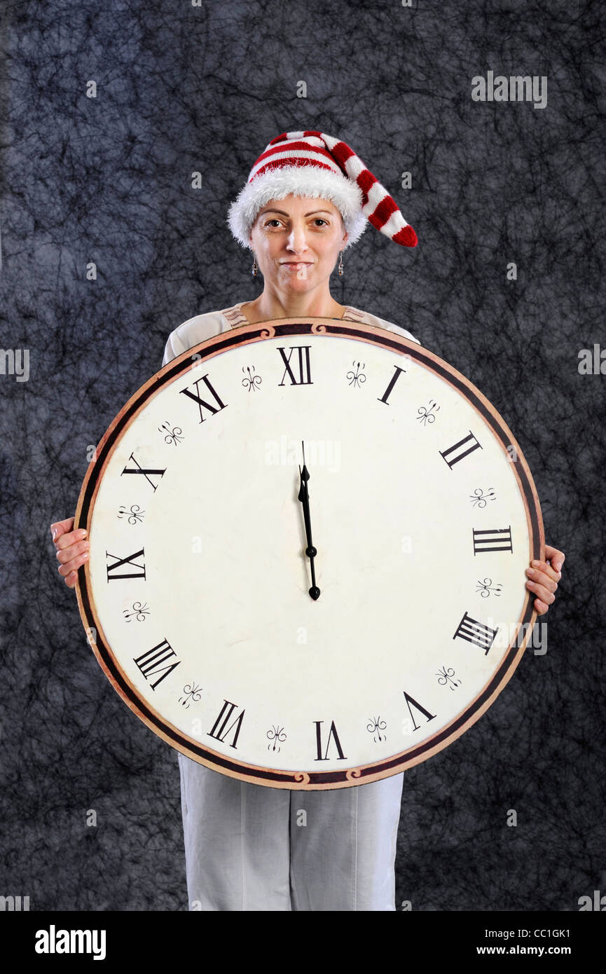 funny woman with xmas hat and vintage midnight clock Stock Photo - Alamy