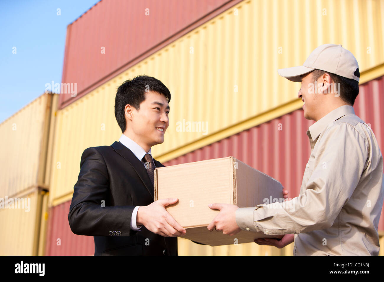 businessman and shipping industry worker giving and receiving a ...