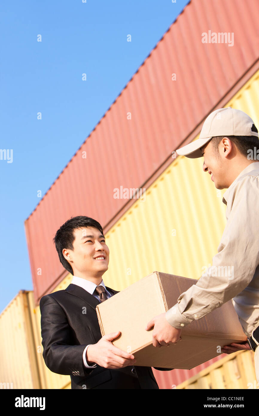 businessman and shipping industry worker giving and receiving a ...