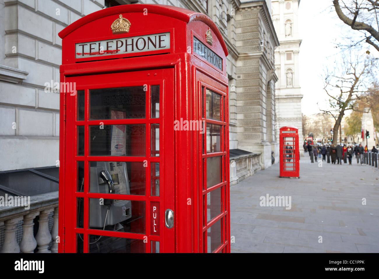 red telephone call boxes on the pavement in whitehall London England UK ...
