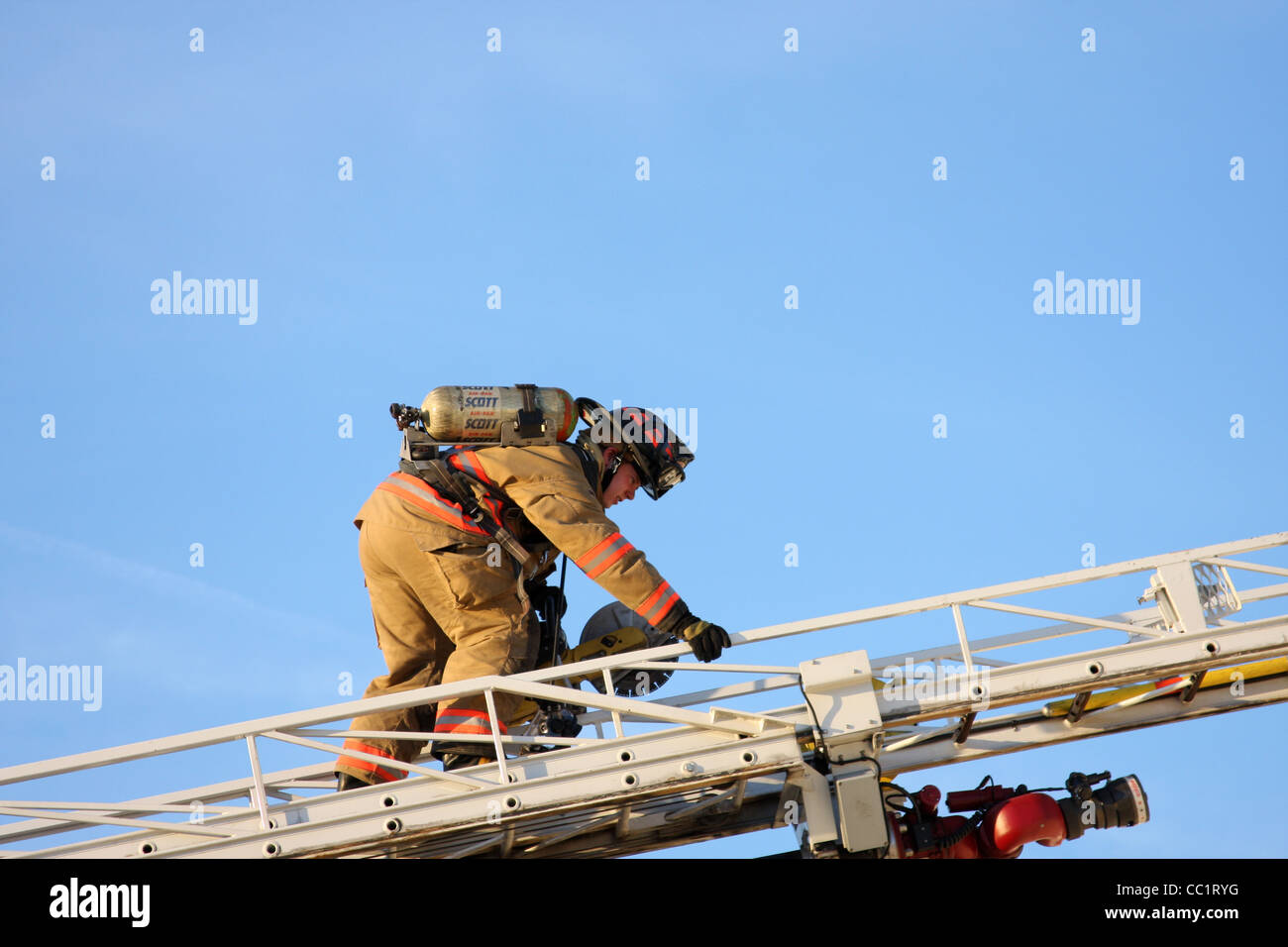 A firefighter climing over to a roof on a ladder fire truck Stock Photo ...
