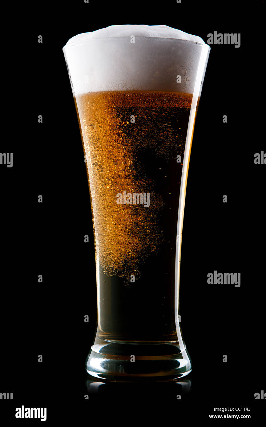 Beer into glass on a black Stock Photo - Alamy