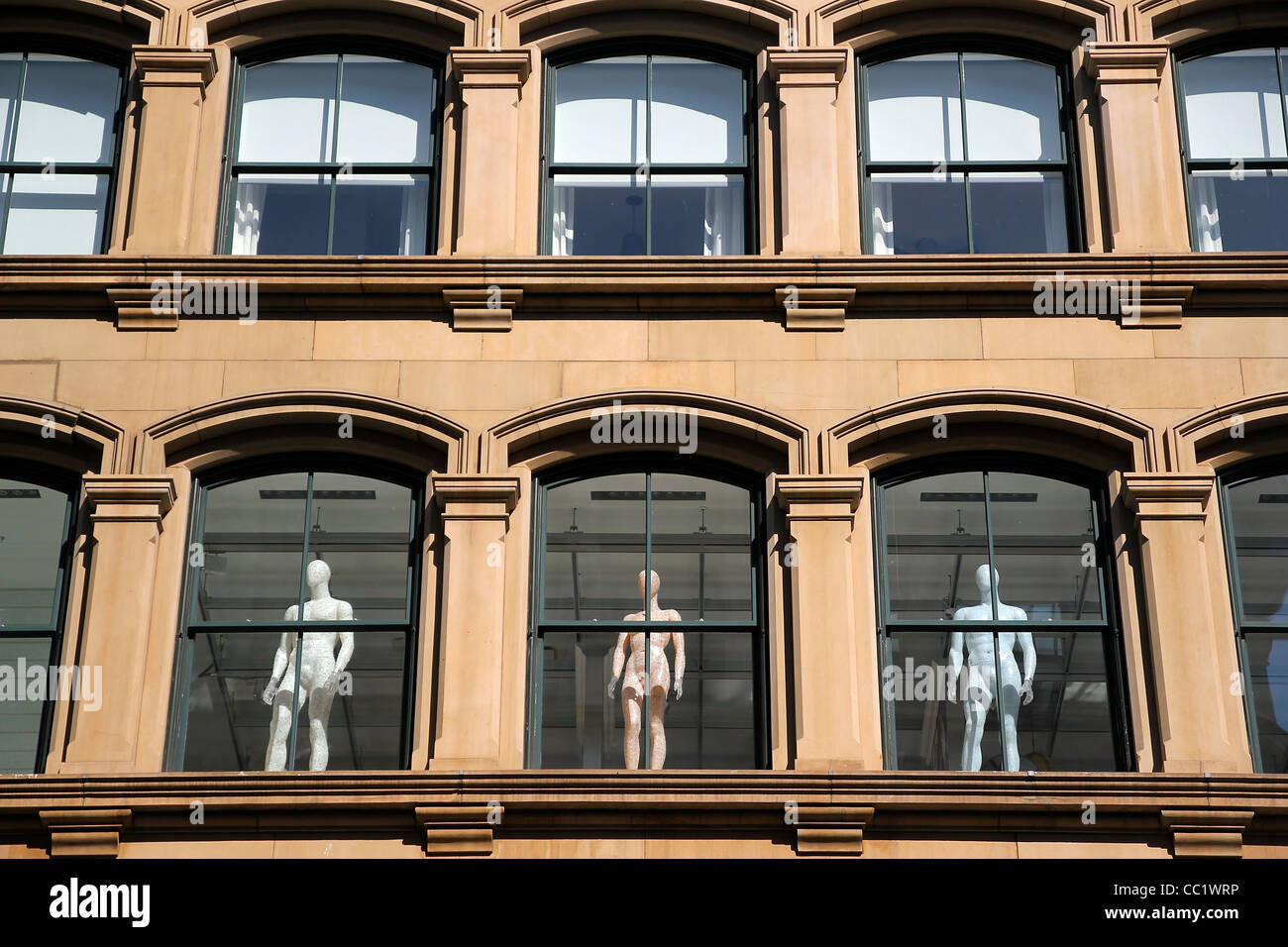 Human figures stand in the windows of a building in Manhattan's Soho ...