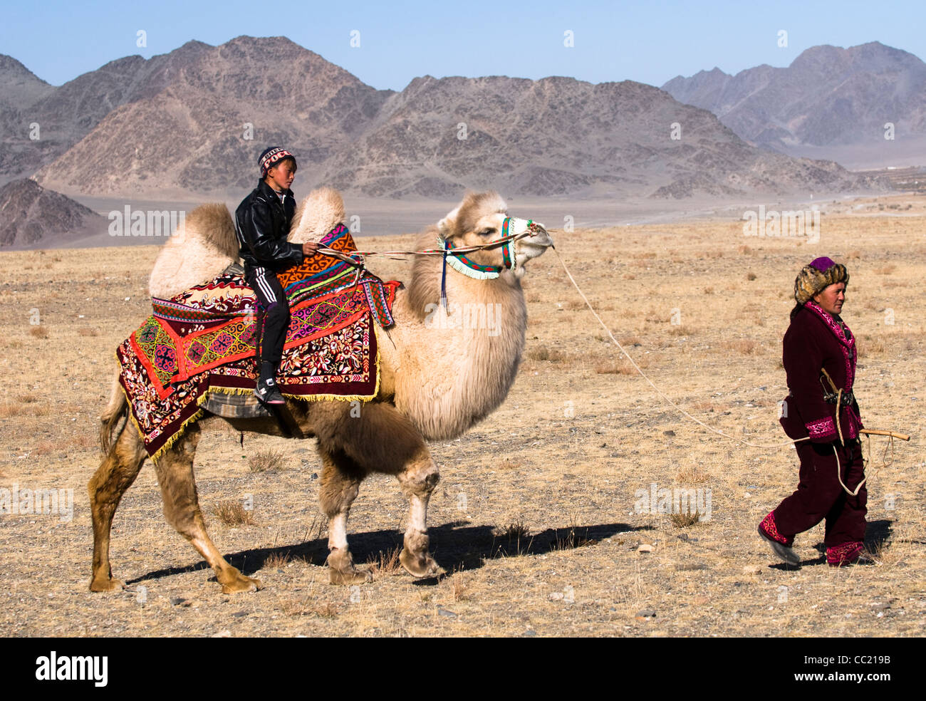 A Kazakh herder with his son in the vast steppe of the Altai region of ...