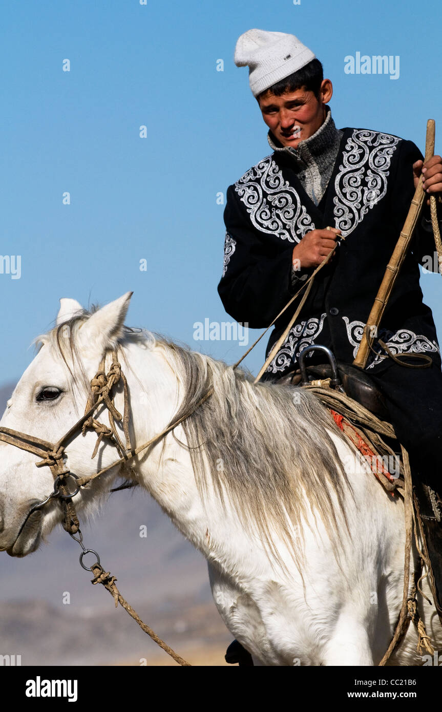 A Kazakh man riding his white horse in the Altai mountains Stock Photo ...