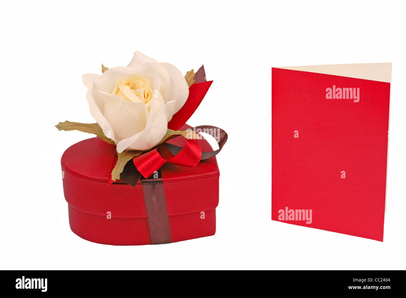Heart shape red chocolate box with rose and a red card isolated over ...