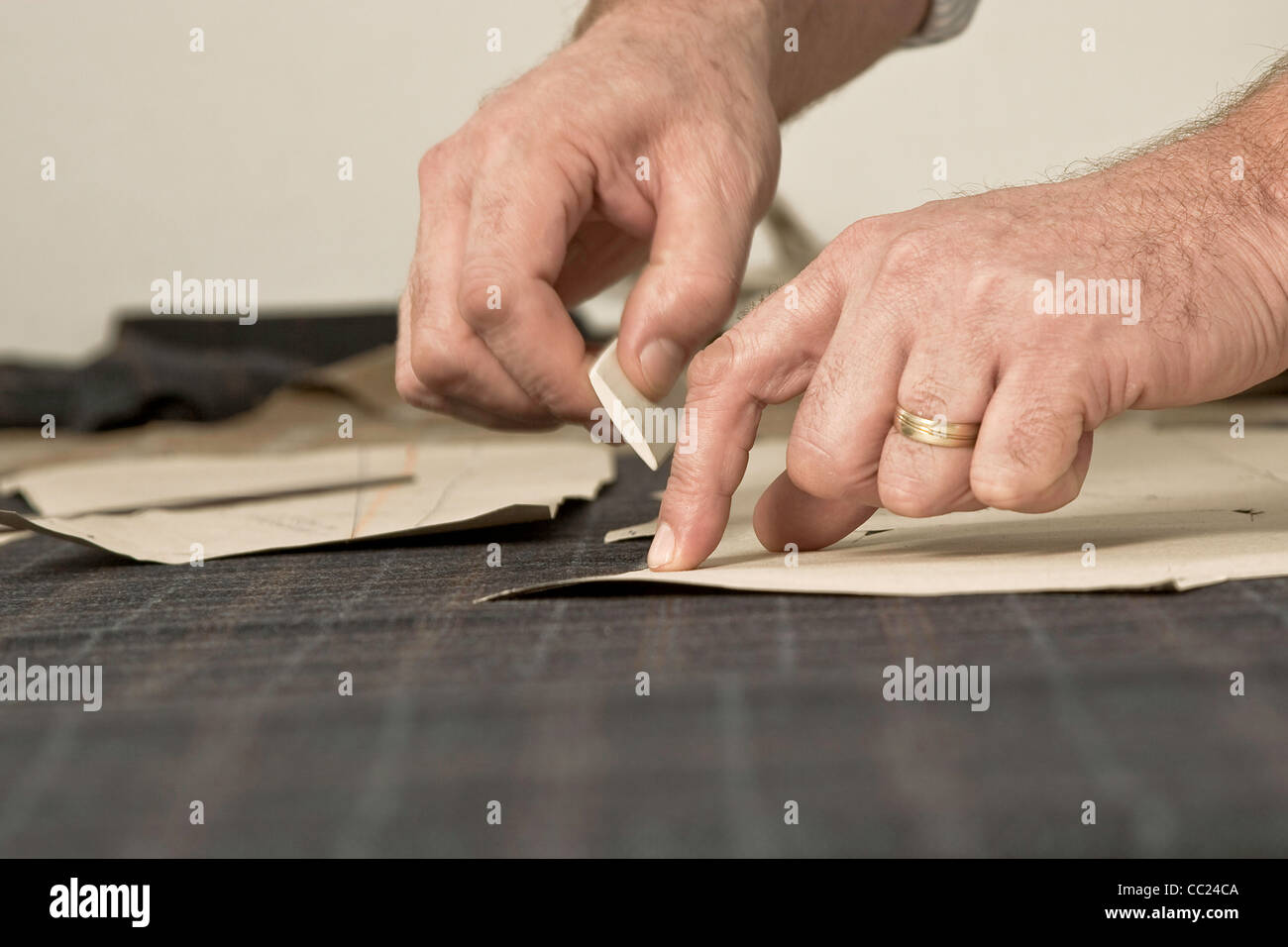 Tailor at work, drawing line on fabric with chalk Stock Photo - Alamy