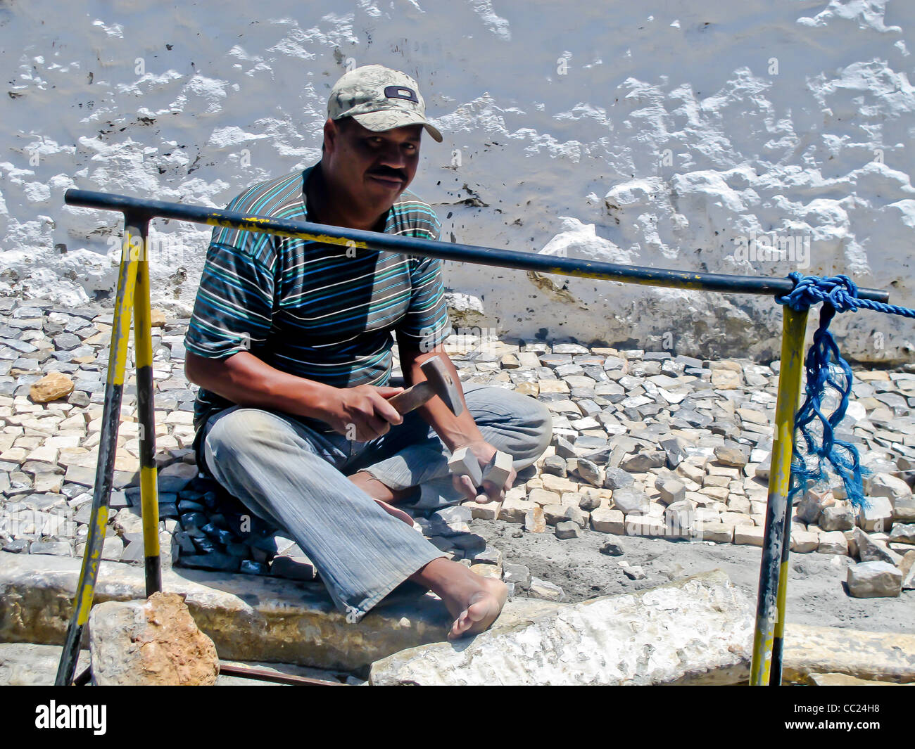Man laying a pavement or sidewalk with individual stones, in Salvador ...