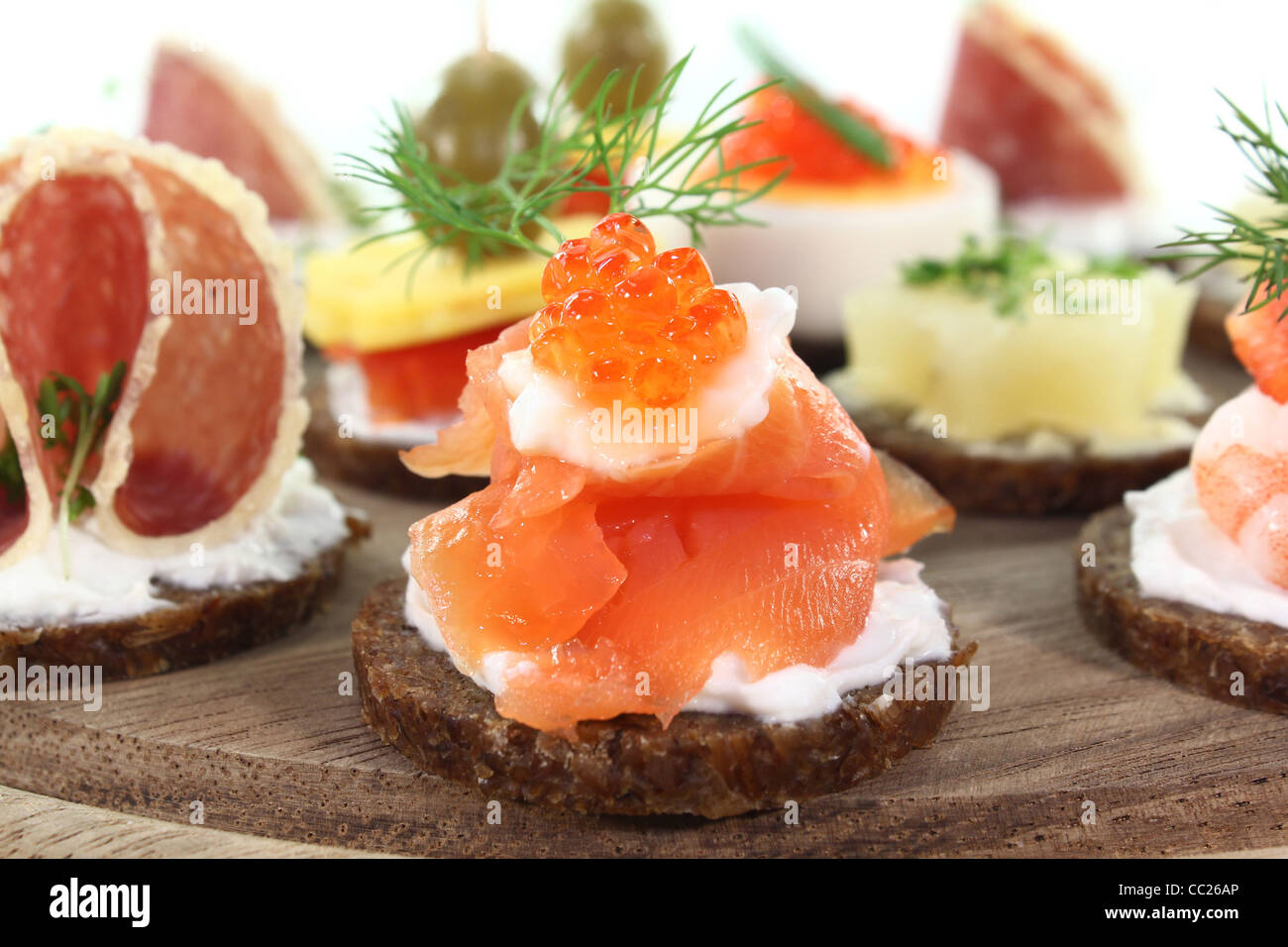 different canapés on a wooden board on a white background Stock Photo ...