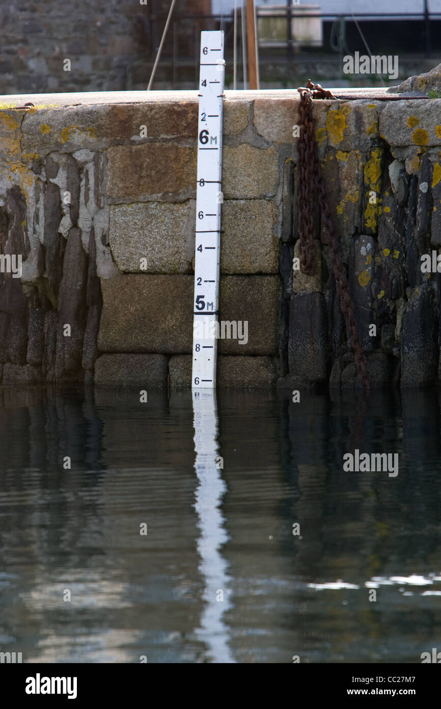 A tide marker against the granite sea wall in Falmouth, Cornwall Stock ...