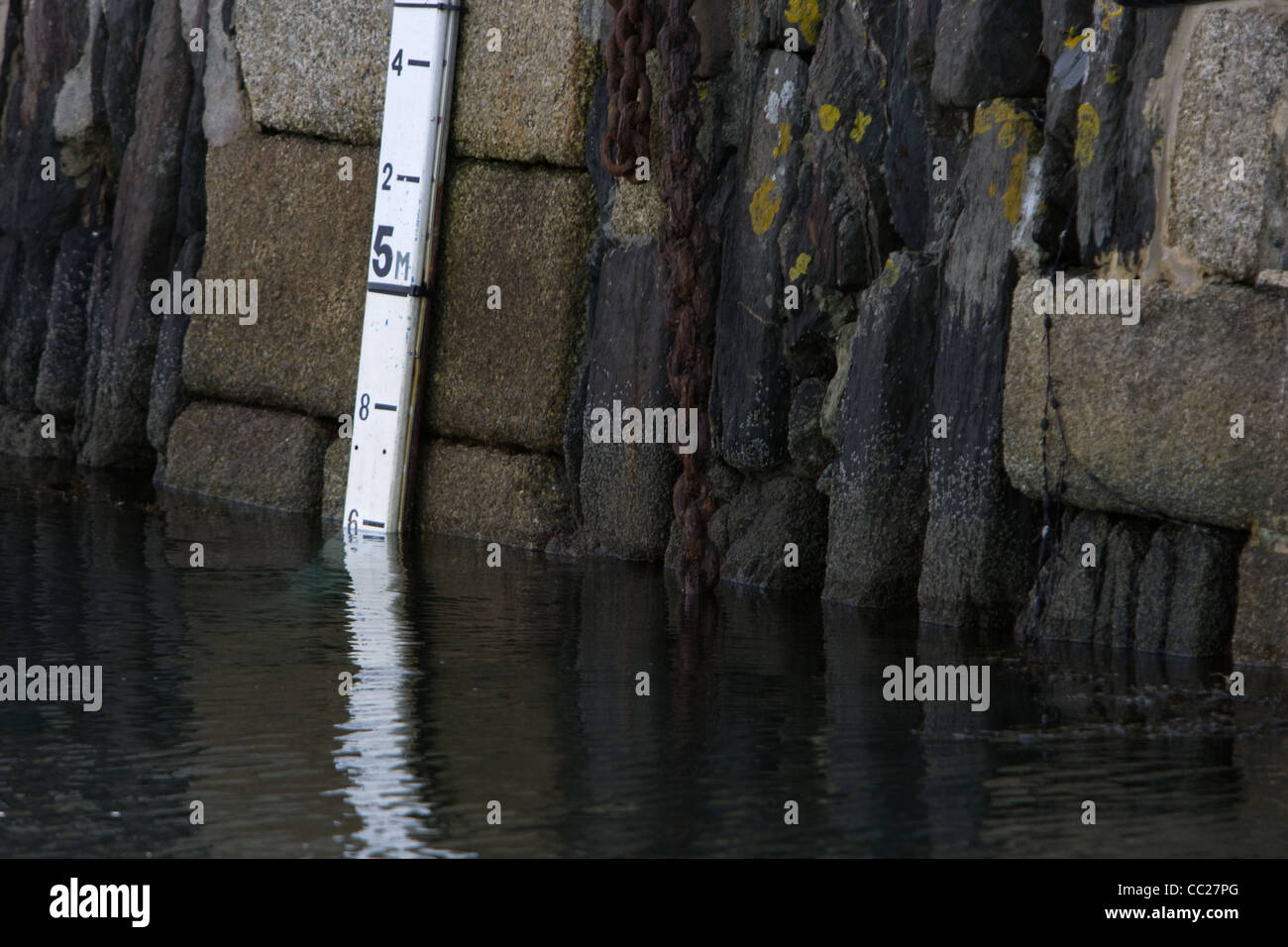 A tide marker against the granite sea wall in Falmouth, Cornwall Stock ...