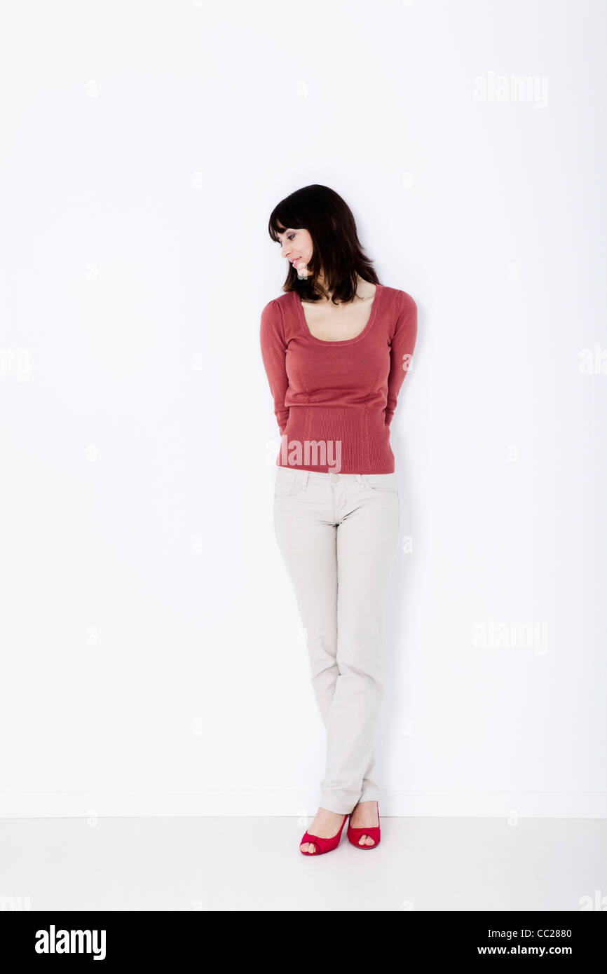 Beautiful woman standing and looking down. Studio shot Stock Photo - Alamy