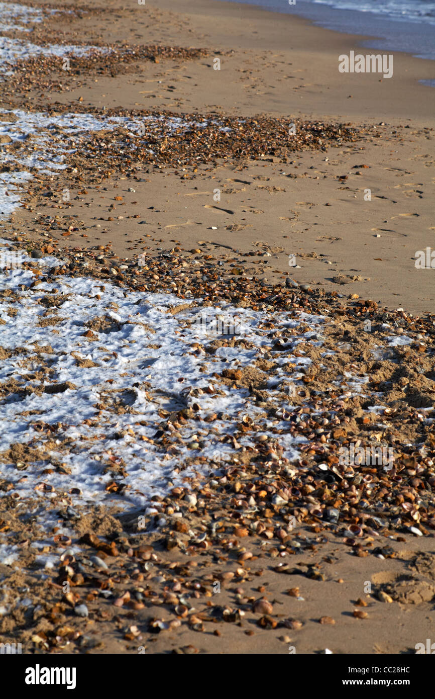 A sprinkling of snow on the sand and pebbles on the beach at ...