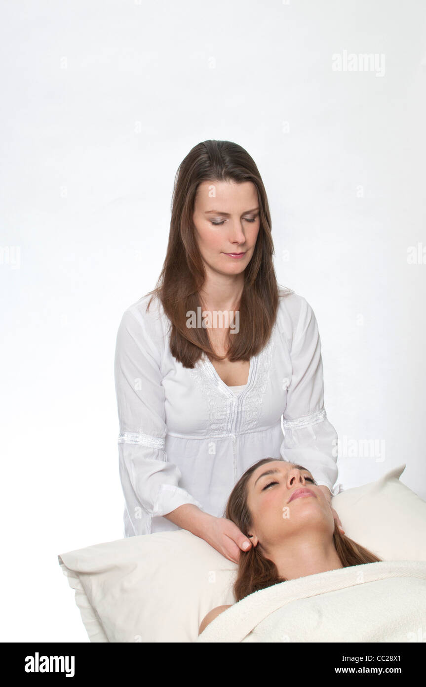 A young woman performing a Reiki treatment on a patient Stock Photo - Alamy