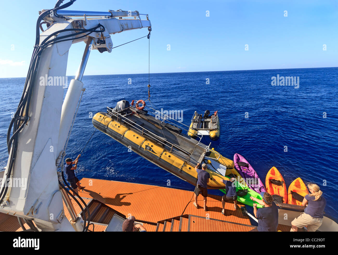 Crew winches passenger skiffs into water from American Safari Cruises ...