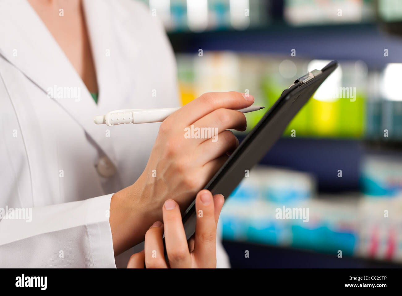 Female pharmacist or assistant is doing inventory or order taking in ...