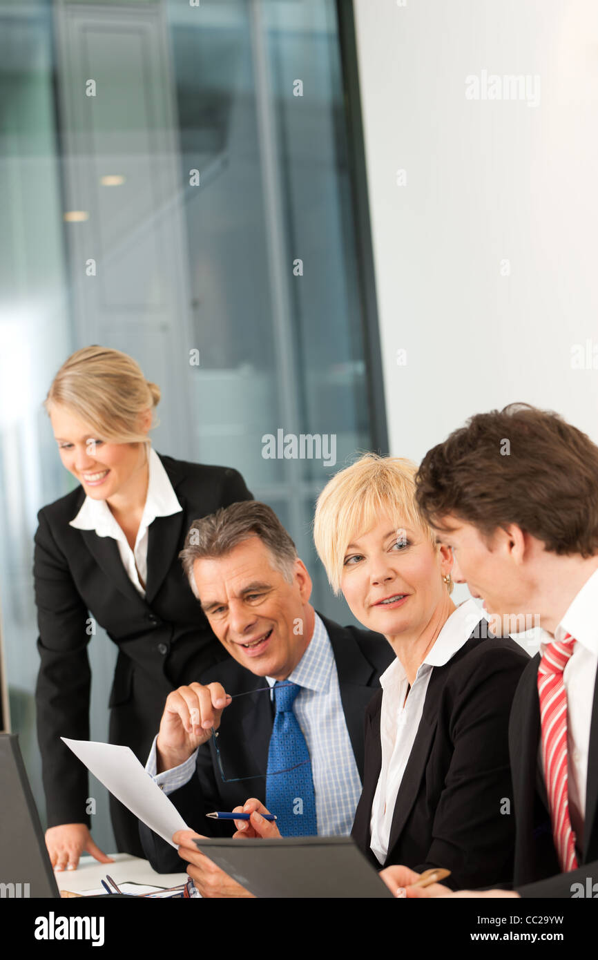 Business - team meeting in an office with laptop, the boss with his ...