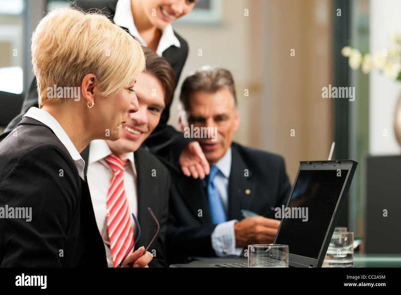 Business - team meeting in an office with laptop, the boss with his ...