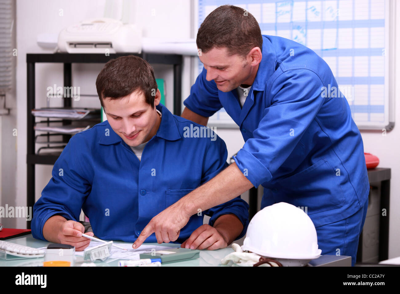 Manual workers in an office Stock Photo - Alamy