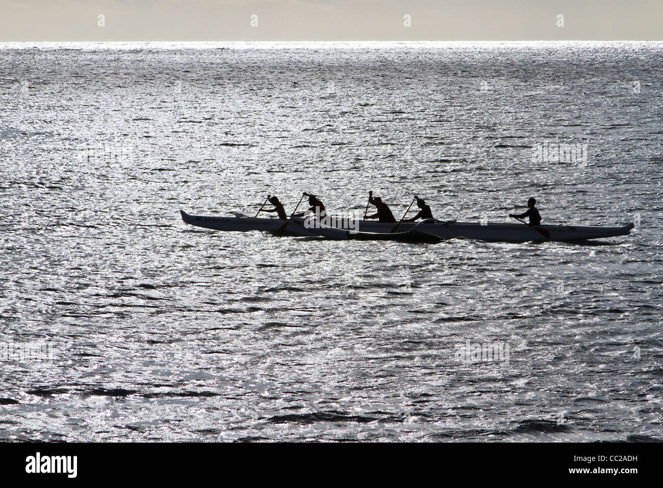 Local youths paddle a traditional outrigger Hawaiian canoe in the ...