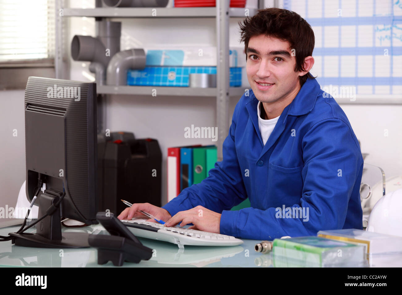 Plumber typing at a computer Stock Photo - Alamy