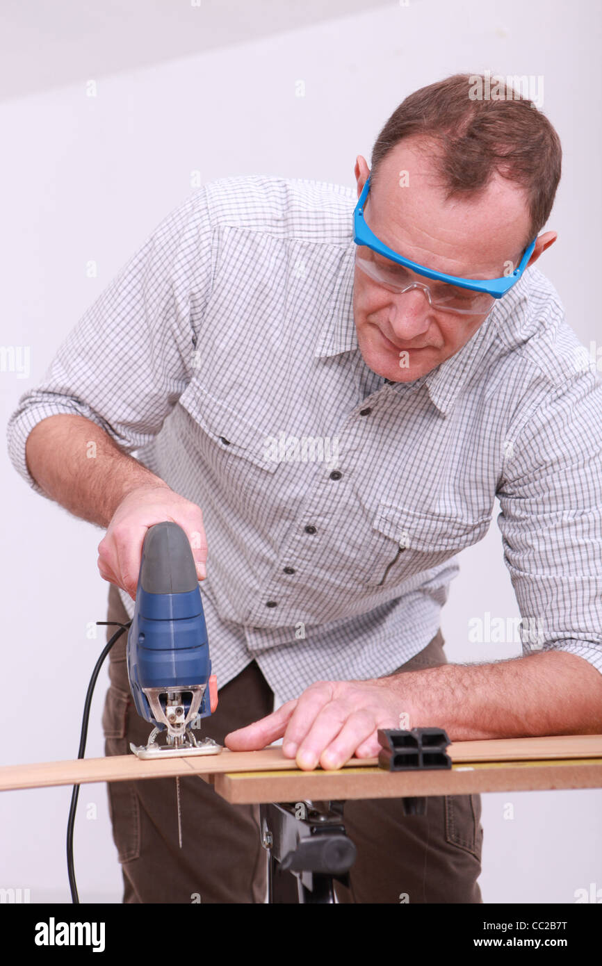 Carpenter with goggles using drill Stock Photo - Alamy