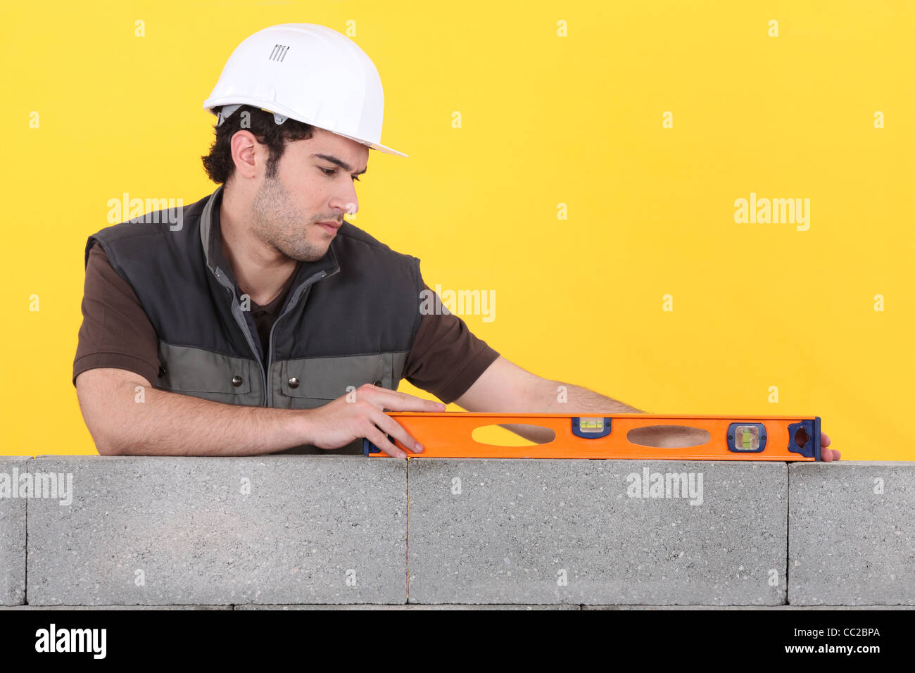 Man with spirit level checking wall Stock Photo - Alamy