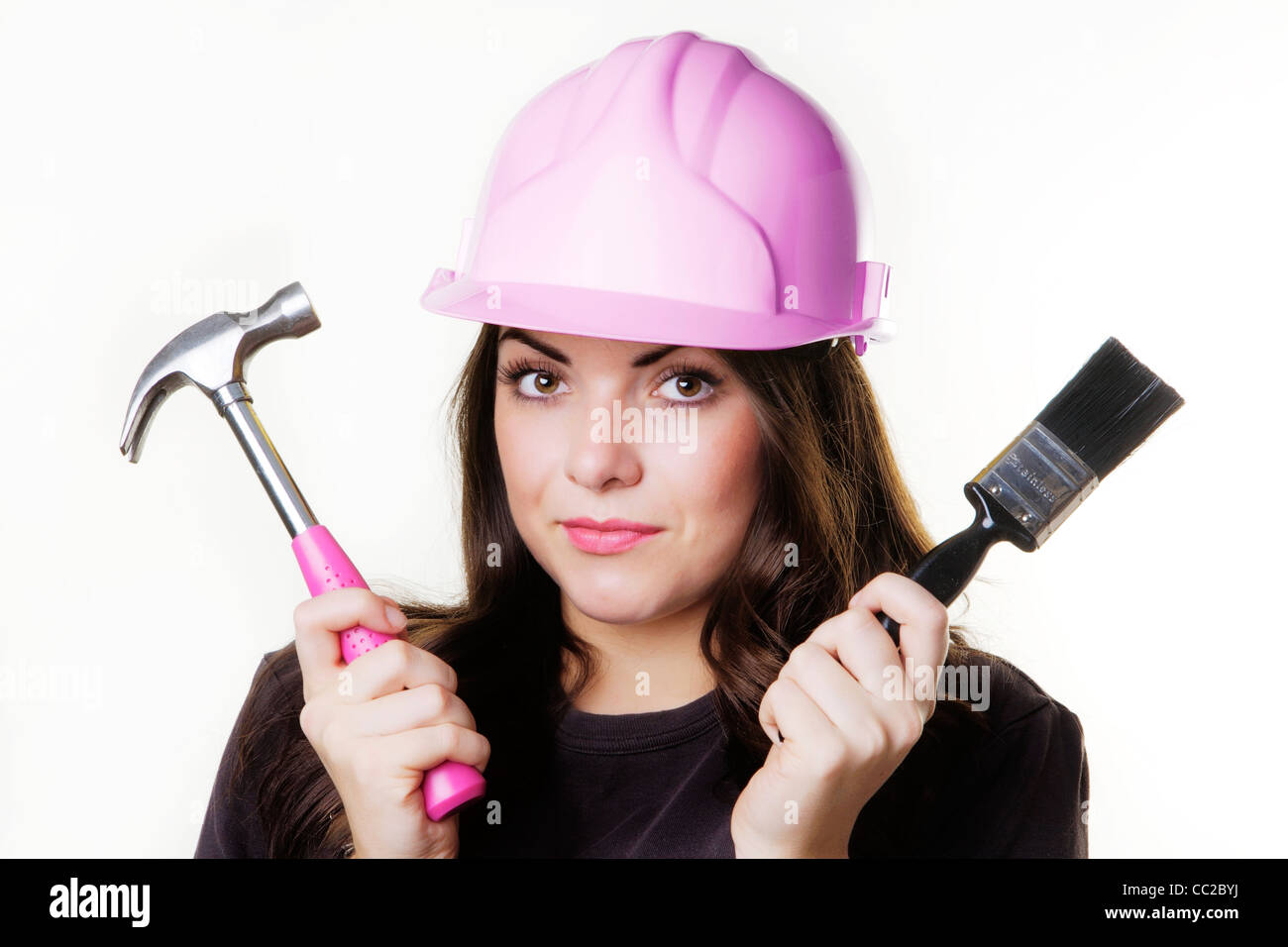 young woman with a hard hat and hammer getting ready to do some DIY ...