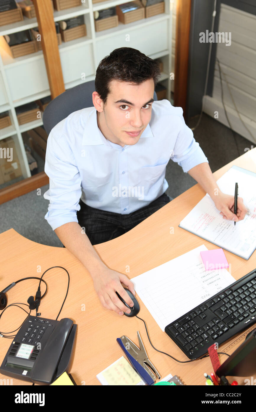 Young man working at an office desk Stock Photo - Alamy