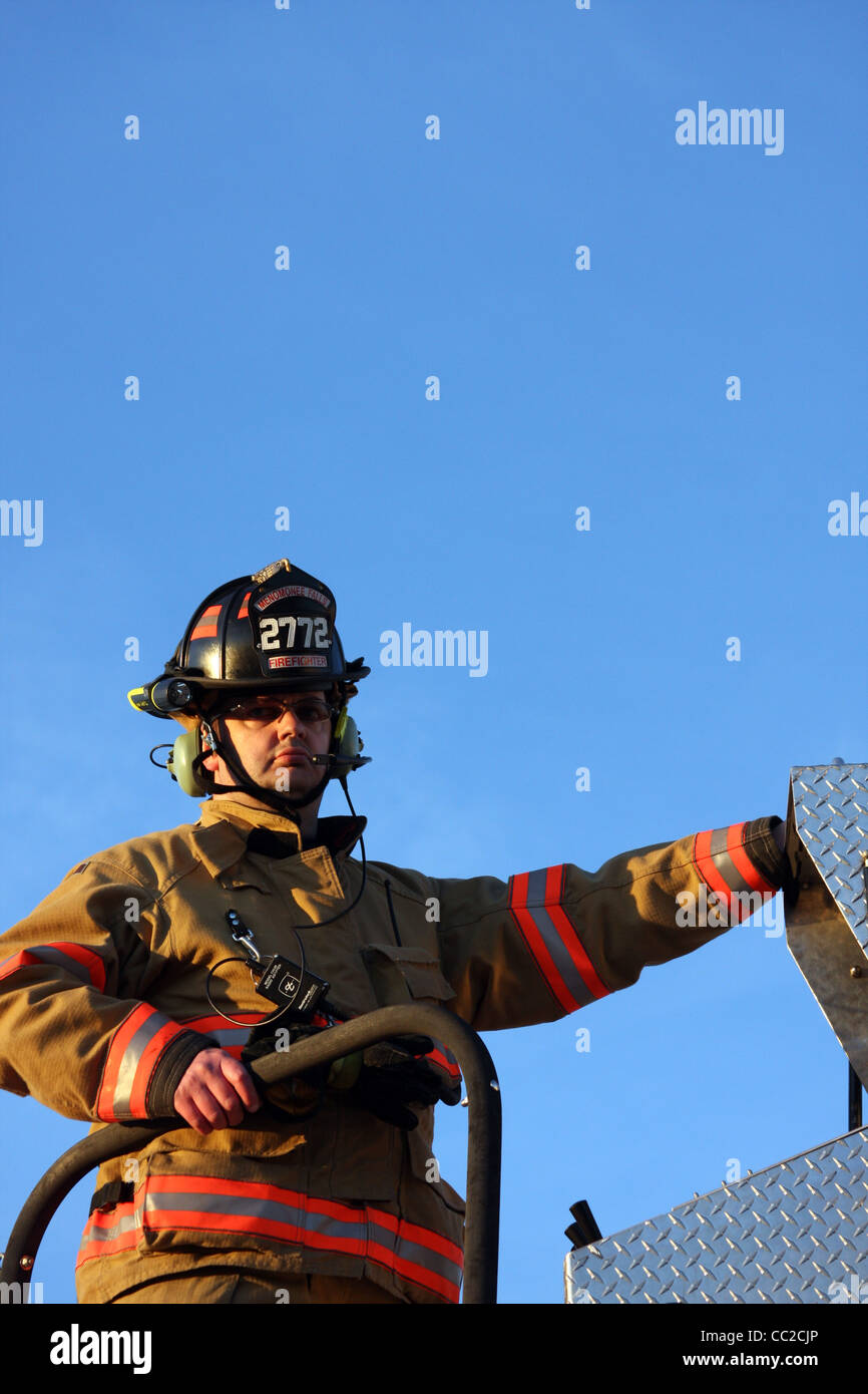 A firefighter on the controls of a ladder truck Stock Photo - Alamy