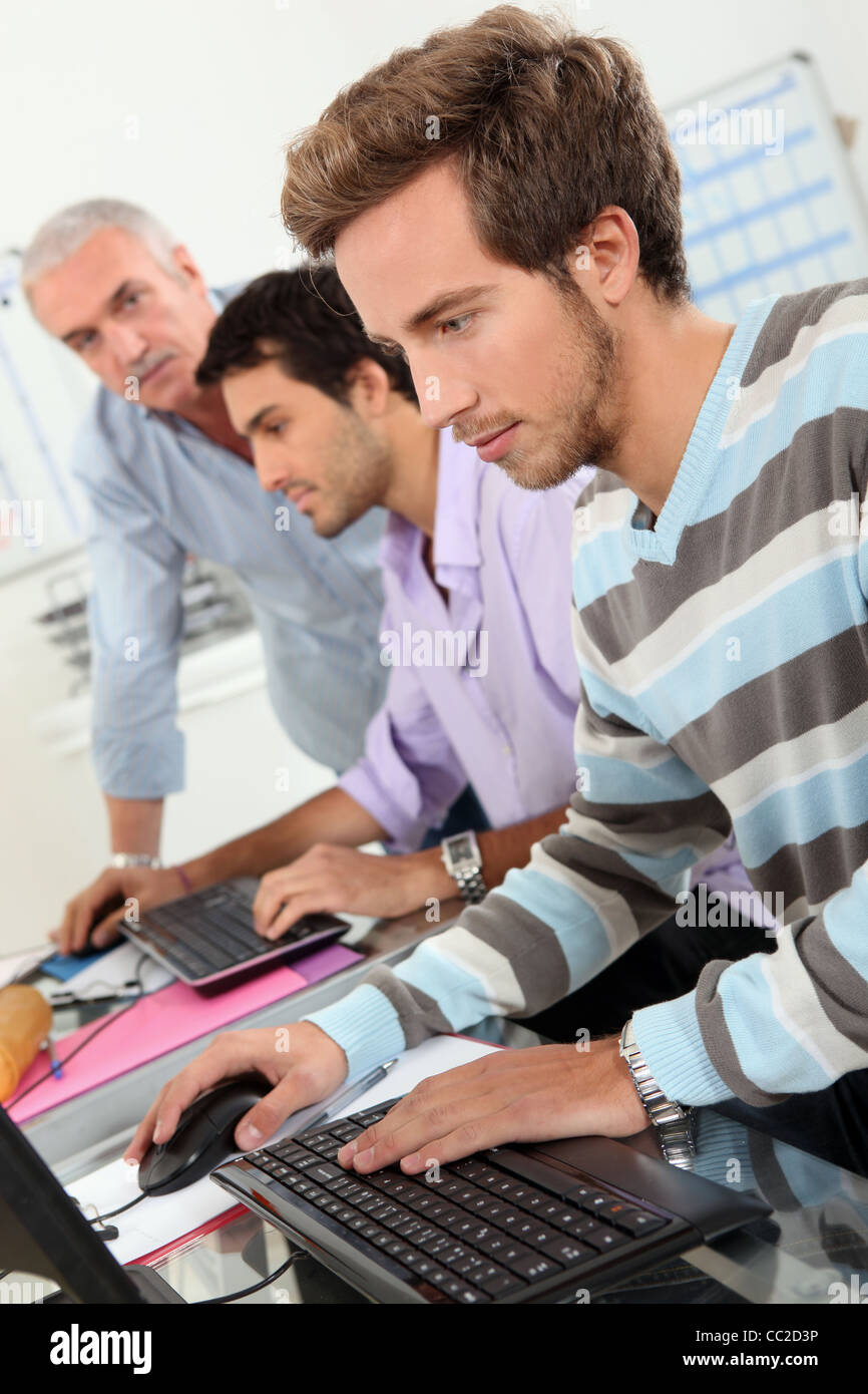 Young men using computers Stock Photo - Alamy
